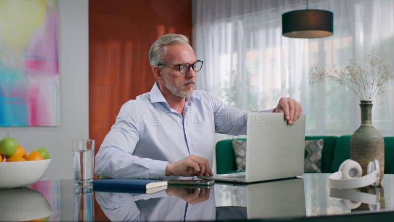 Mature Man Sit Down at Table and Start Working on Laptop at Home Stock ...