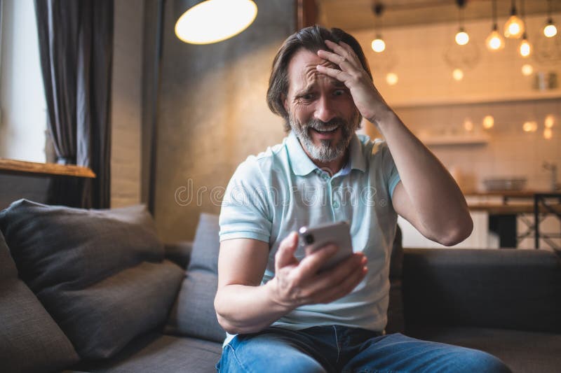 Mature Man Spending Time at Home and Watching Something on His ...