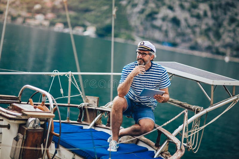 Man Standing on the Deck of His Boat and Using Digital Tablet on a ...