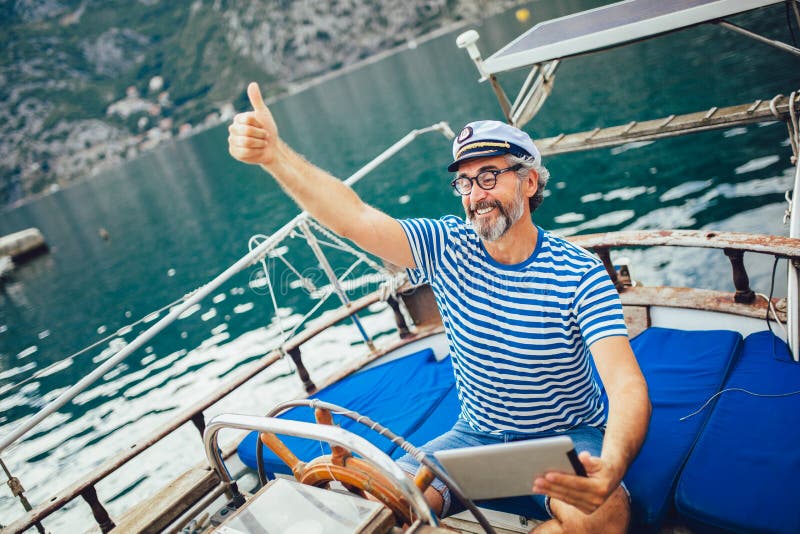 Man Standing on the Deck of His Boat and Using Digital Tablet on a ...
