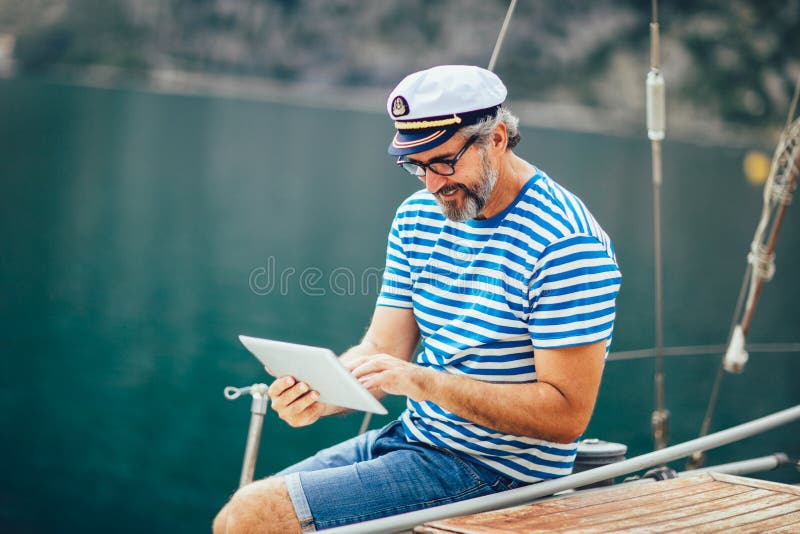 Man Standing on the Deck of His Boat and Using Digital Tablet on a ...