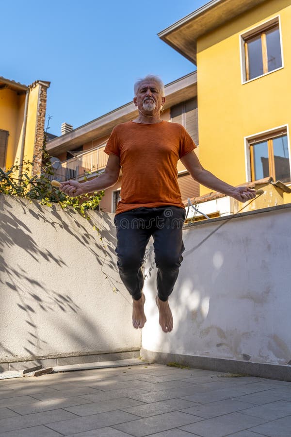 Mature Man is Training by Jumping Rope on the Terrace Stock Photo ...