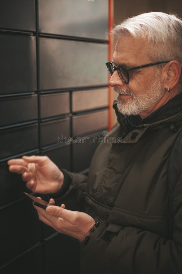 Mature Man Uses a Self-service Mail Machine. Terminal for Receiving ...
