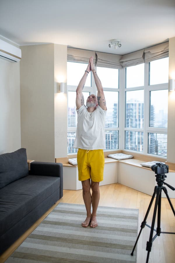 A Mature Man in White Tshirt Doing Yoga Tutorial Online Stock Image ...