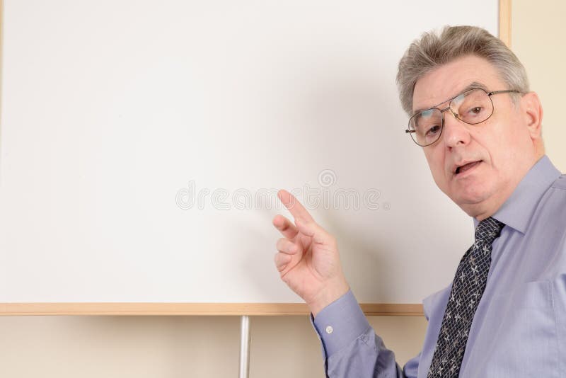 Mature man at whiteboard stock photo. Image of showing - 4180522