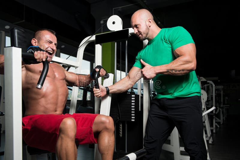 Man Train Chest on Machine with Personal Trainer Stock Photo - Image of ...