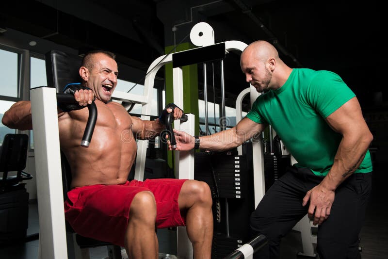 Man Train Chest on Machine with Personal Trainer Stock Photo - Image of ...