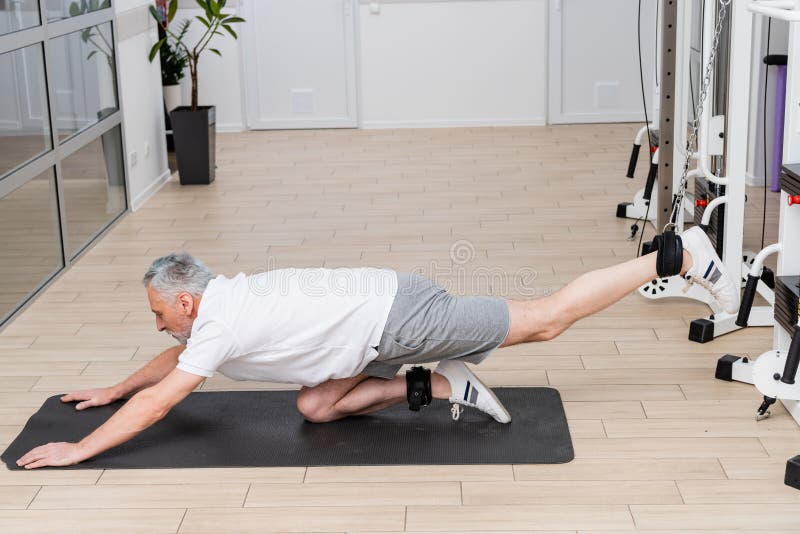 Mature Man Working Out Leg on Stock Photo - Image of indoors, medicine ... Mature Man Working Out Leg on Stock Photo - Image of indoors, medicine ...