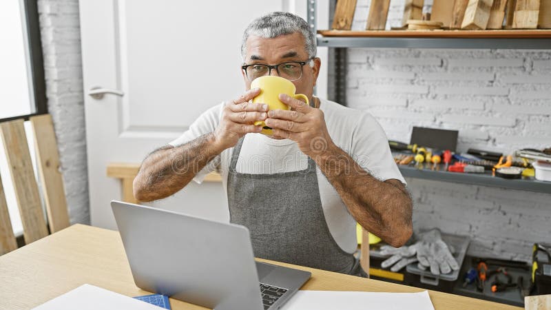 Mature Man in Workshop Examining Cup, Surrounded by Carpentry Tools ...