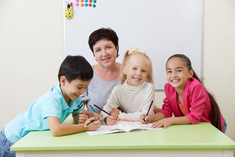 Mature Preschool Teacher and Children in a Classroom during Class Stock ...