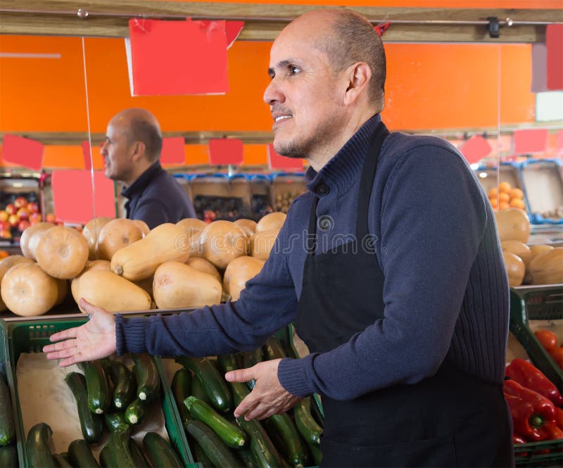 Mature Salesman with Zucchini in Vegetable Shop Stock Photo - Image of ...