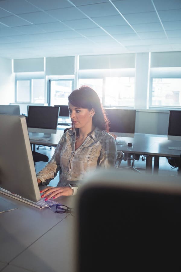 Female Office Worker Typing on Computer Wearing Plaid Shirt in Open ...