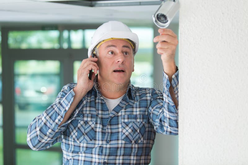 Mature Technician Installing Cctv and Talking on Phone Stock Image ...