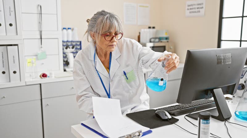 Mature Woman Scientist Analyzing Chemicals in a Laboratory Setting ...