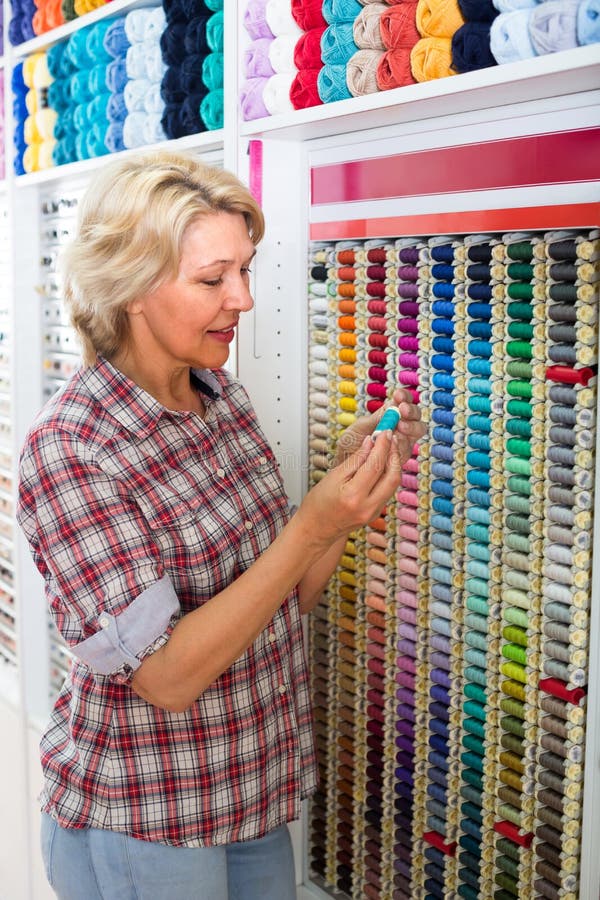 Mature Woman in Sewing Store. Stock Image - Image of silk, spool: 221368755