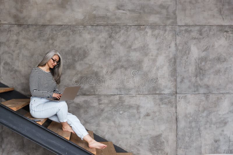 Mature Woman Sitting on Steps Using Laptop Computer Stock Photo - Image ...