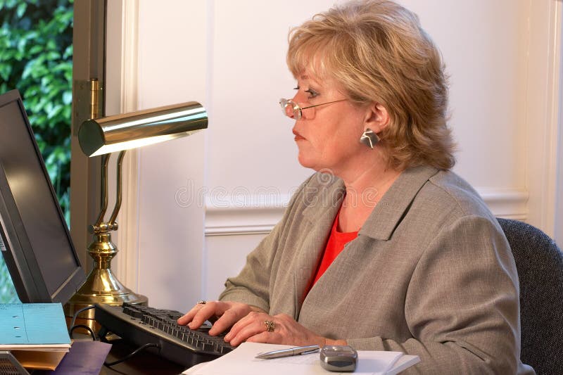 Mature woman typing stock image. Image of fifties, glasses - 20874649
