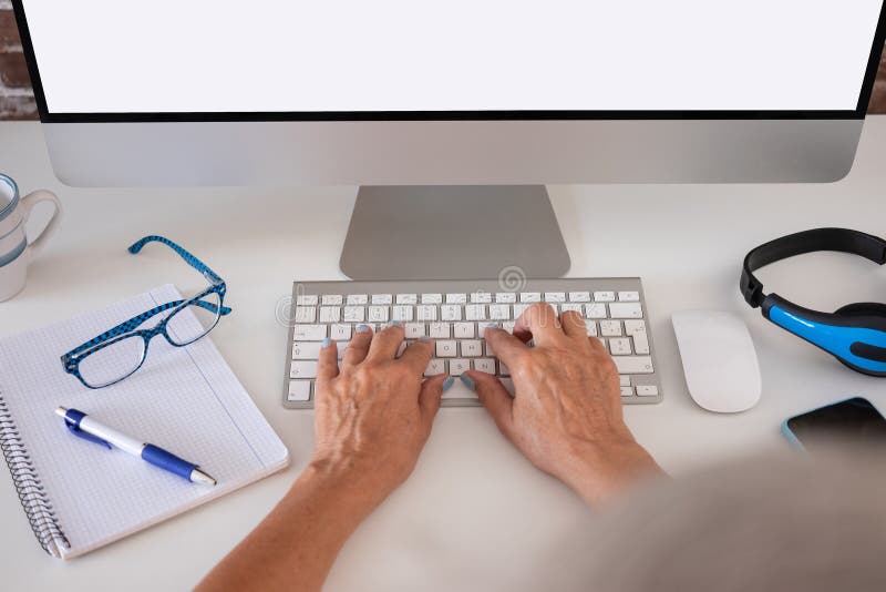 Mature Woman Typing on Keyboard Using Computer. White Desktop Stock ...