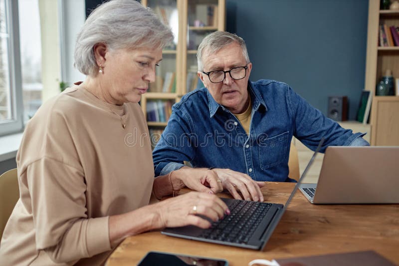 Mature Woman Using Computer with Man Helping Stock Image - Image of ...