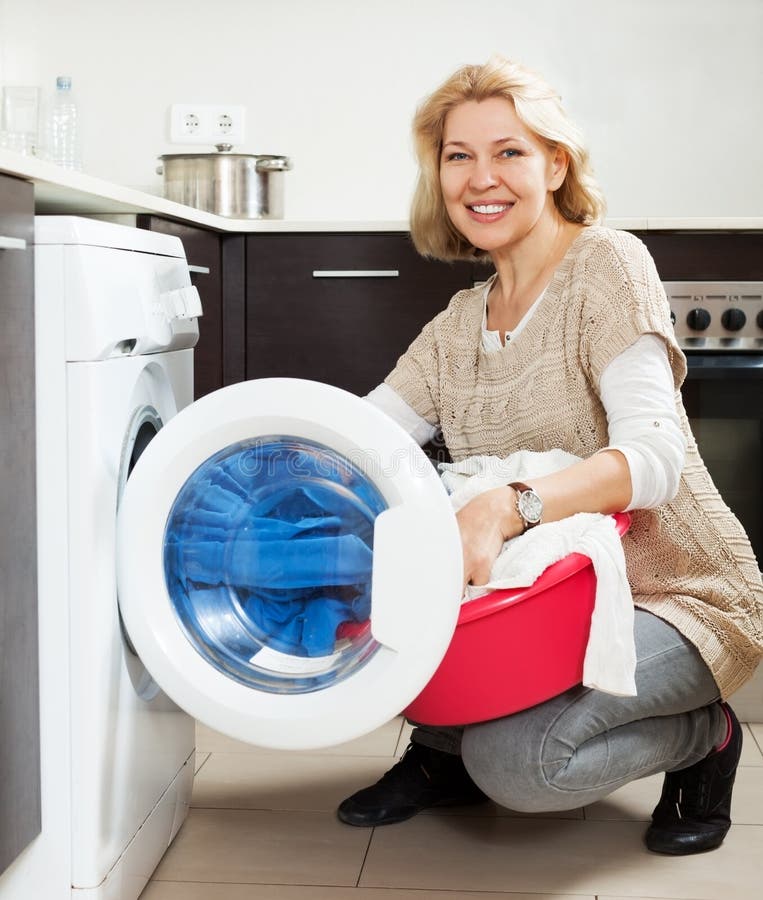 Mature Woman Using Washing Machine at Home Stock Photo - Image of ...