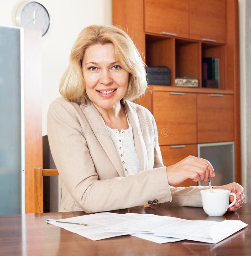 Mature Woman Working with Documents at Table in Home Stock Image ...