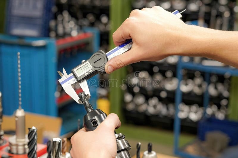 A Worker in a Tool Warehouse Inspects and Selects Cutters for Work on a ...