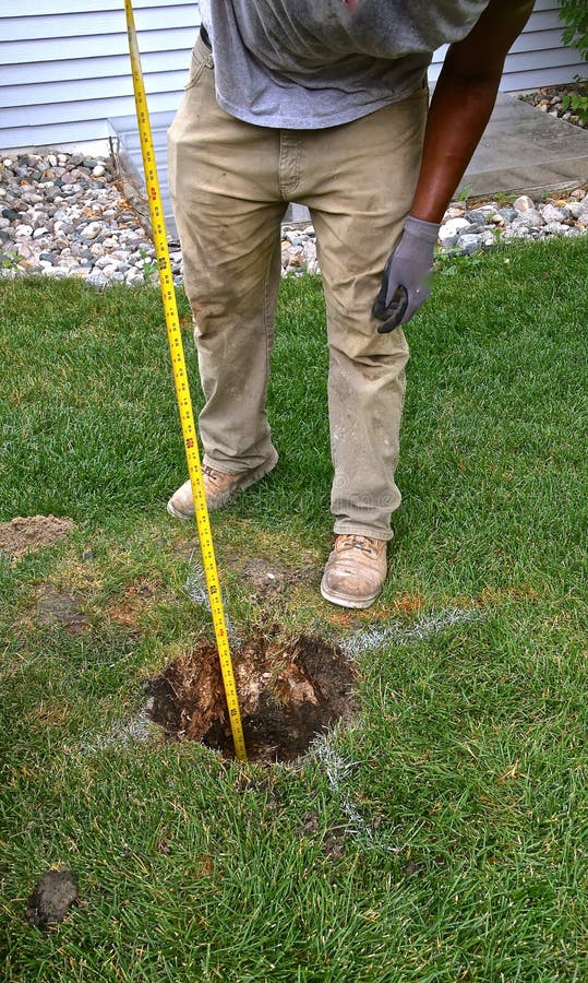 Digging and Measuring Depth for a Pole Hole for a New Fence Stock Photo ...