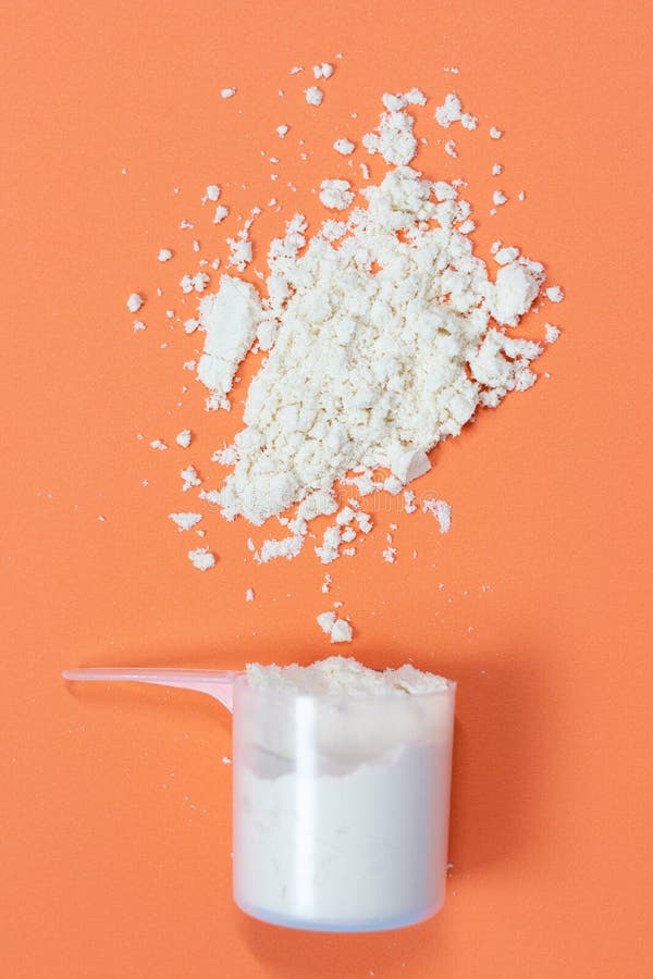 Measuring Spoon with Scattered Protein Powder on a Orange Background ...