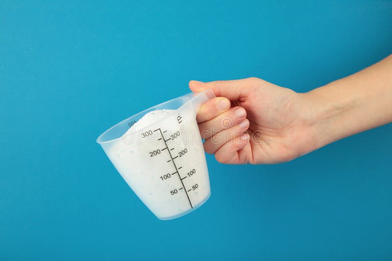 Measuring Spoon with Washing Powder in Hand on Blue Background Stock ...