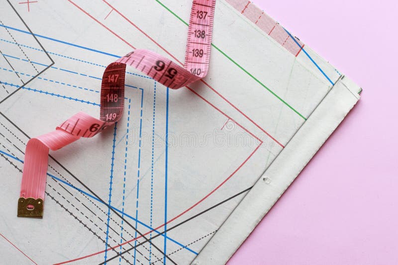 Measuring Tape and Paper Pattern for Sewing on a Pink Background ...