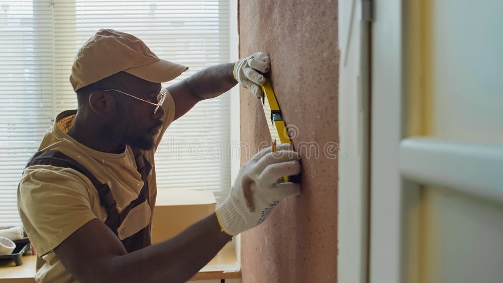 Measuring Wall with Level Tool by Worker Installing Paneling Stock ...