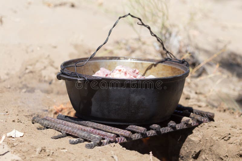 Meat in a cauldron on fire stock photo. Image of burn - 107574996