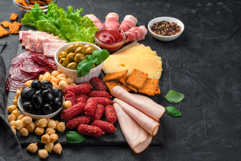 Meat and Cheese Appetizers with Olives and Salad on a Flat Slate Board ...