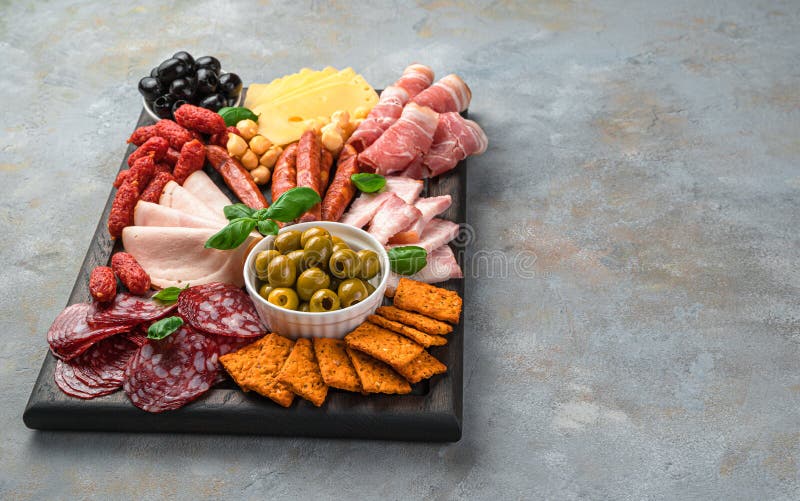 Meat and Cheese Assortment on a Rectangular Board on a Gray Concrete ...