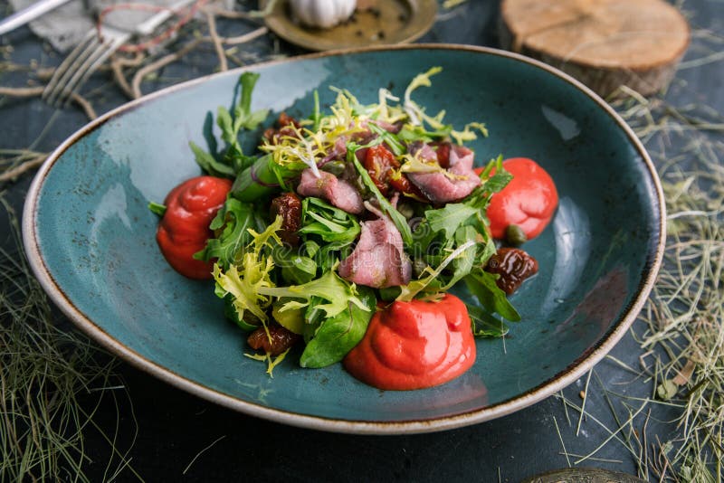 Meat Salad with Fresh Herbs and Dried Tomatoes in a Restaurant Stock ...