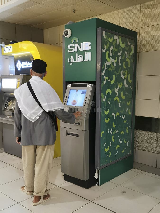 An Unidentified Man Withdraws Money at Saudi National Bank (SNB) Kiosk ... An Unidentified Man Withdraws Money at Saudi National Bank (SNB) Kiosk ...