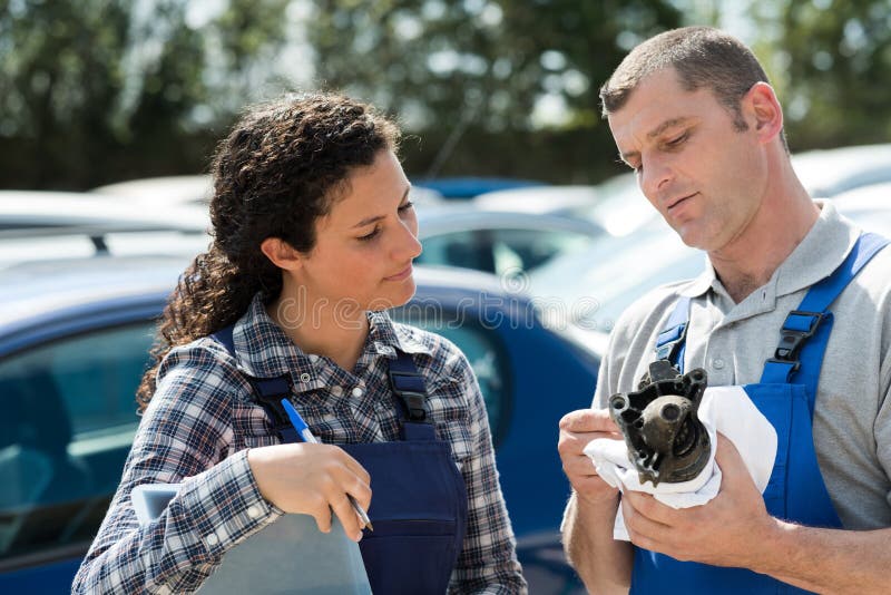Mechanic and Apprentice Looking at Automotive Part Stock Photo - Image ...