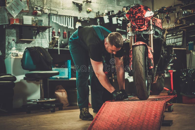 Mechanic Arepairing a Motorcycle in a Workshop Stock Photo - Image of ...