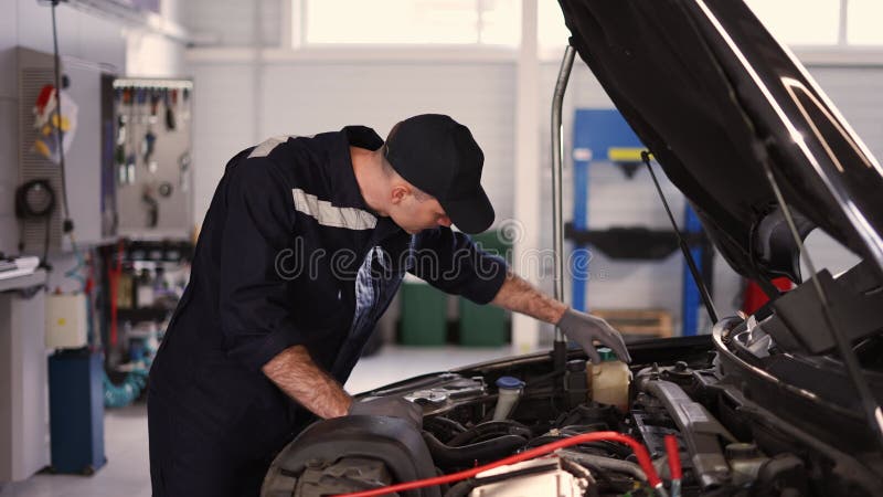 Mechanic in a Auto Repair Shop Checking Engine Manually Stock Video ...