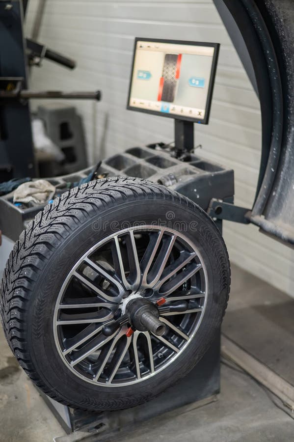Mechanic Balancing a Wheel in a Workshop. Stock Photo - Image of store ...