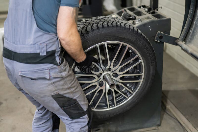 Mechanic Balancing a Wheel in a Workshop. Stock Image - Image of ...