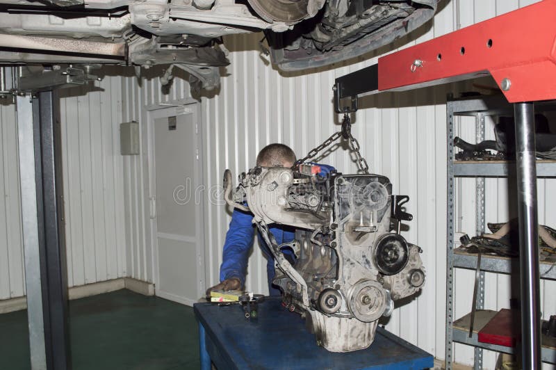 The Mechanic Prepares the Car Engine for Installation on the Car Stock ...