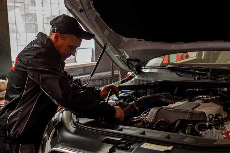 Mechanic in a Car Dealership Working on a Car Engine Stock Image ...