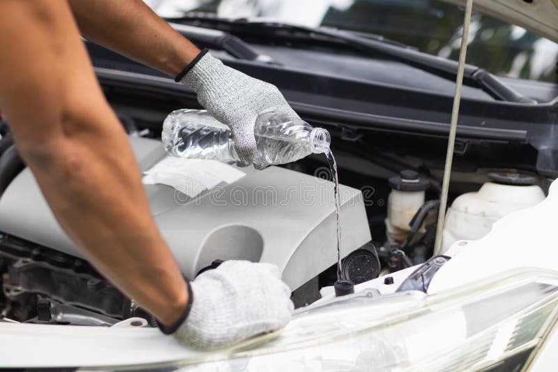 Mechanic is Checking Car and Adding Water To Radiator To Increase the Engine Cooling Capacity ...