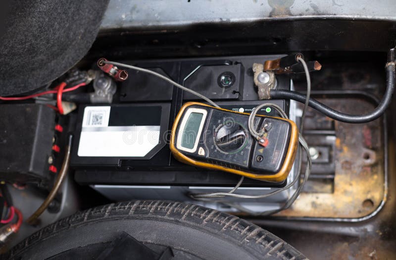 Mechanic Checking a Car Battery Level with Voltmeter Stock Photo ...