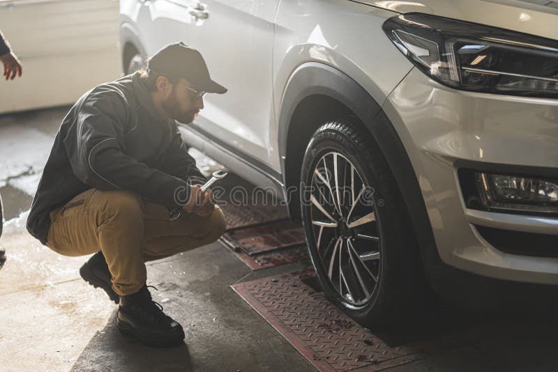 Mechanic Checking Geometry and Suspension of a Car Wheel Using ...