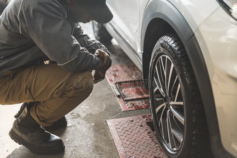 Mechanic Checking Geometry and Suspension of a Car Wheel Using ...