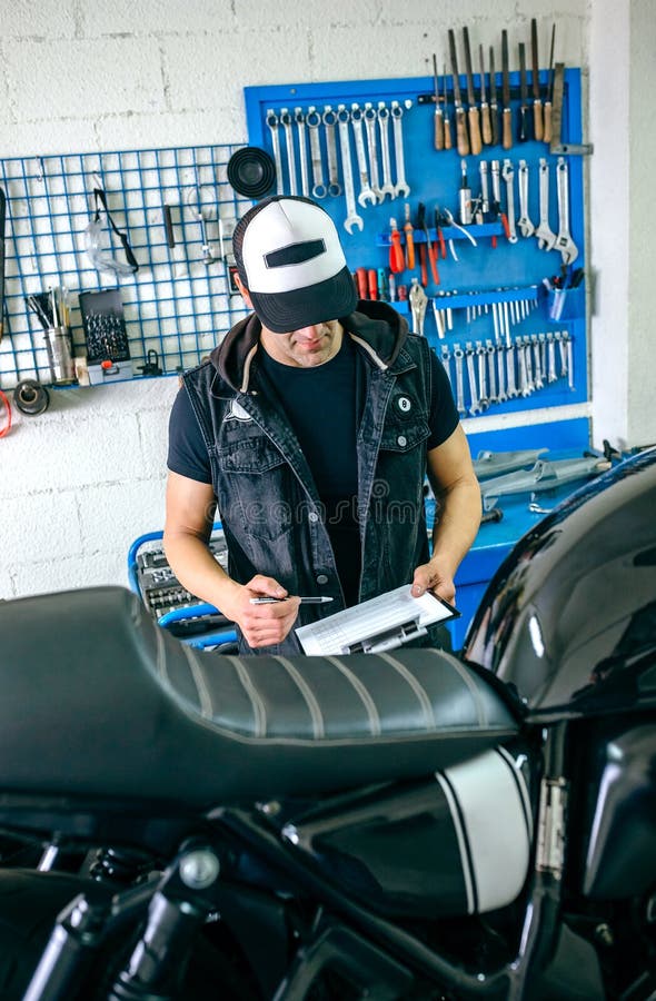 Mechanic Checking Custom Motorcycle with Tablet Stock Photo - Image of ...