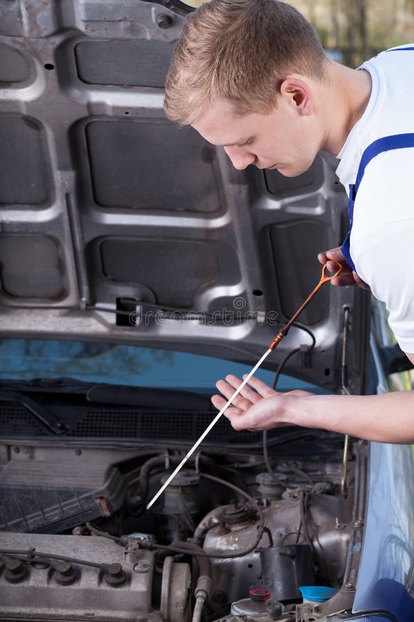 Mechanic Checking Oil Level Stock Image - Image of check, checking ...