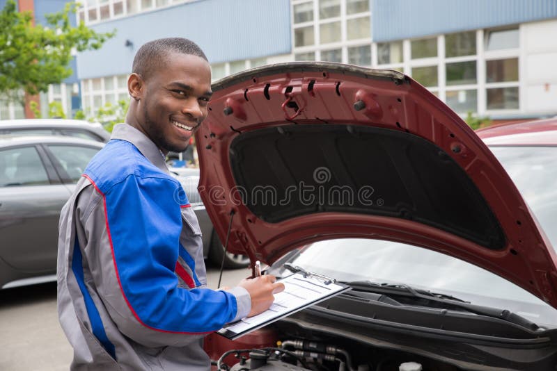 Mechanic with Clipboard in Front of a Car Stock Image - Image of ...